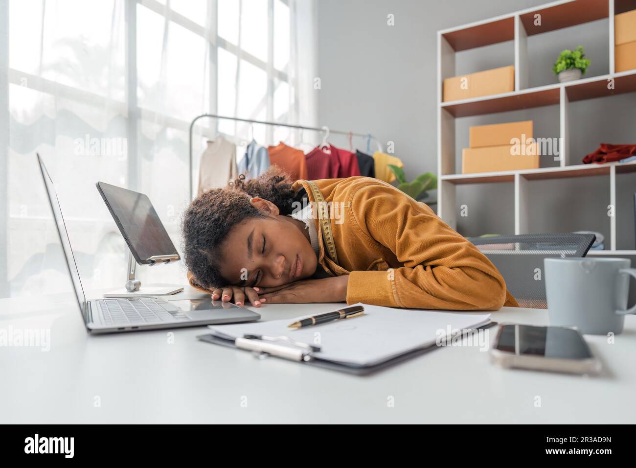 designer woman sleeping on desk in atelier after exhausted from ...