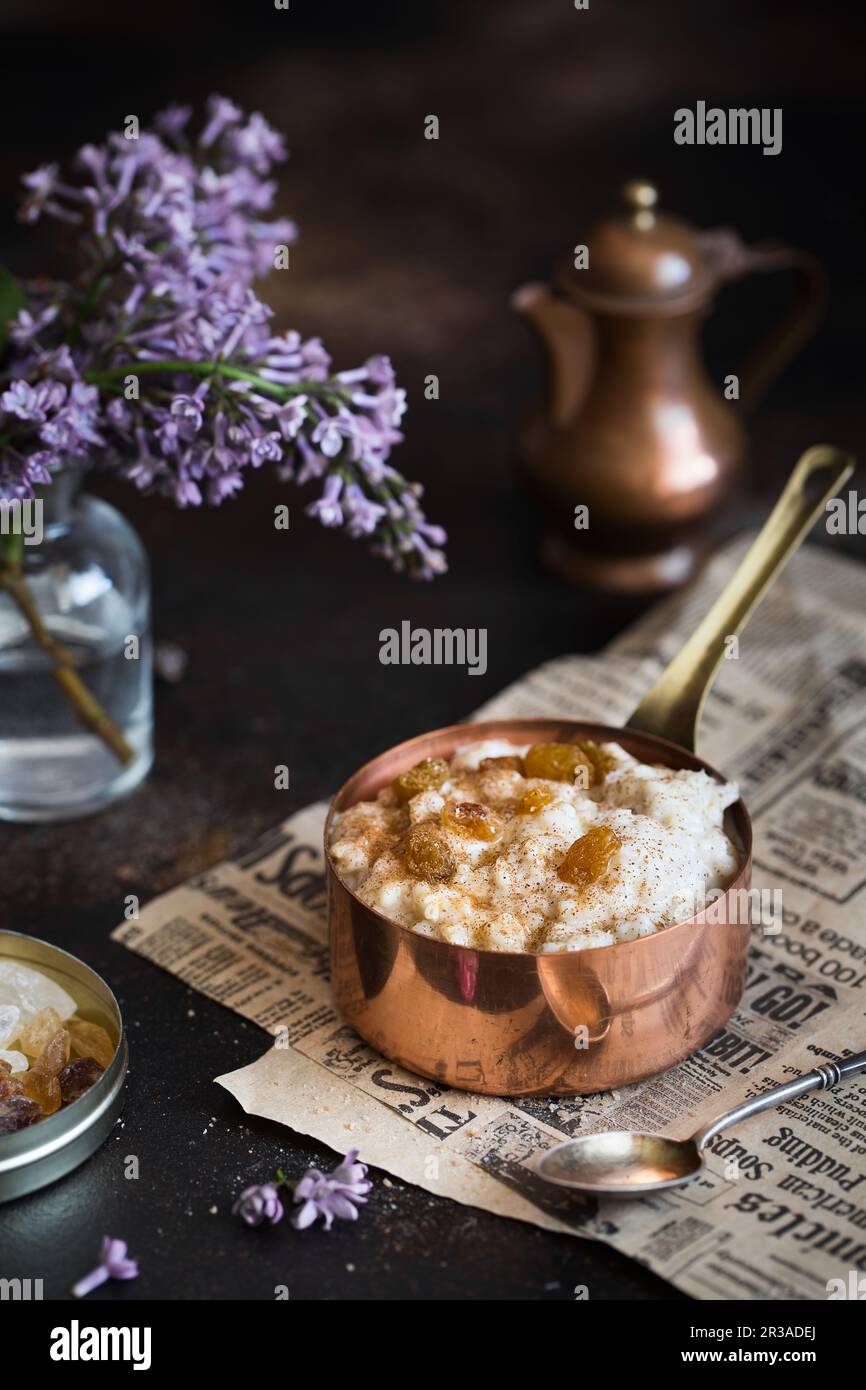 Oatmeal porridge with raisins and cinnamon in a copper cocotte. Oatmeal ...