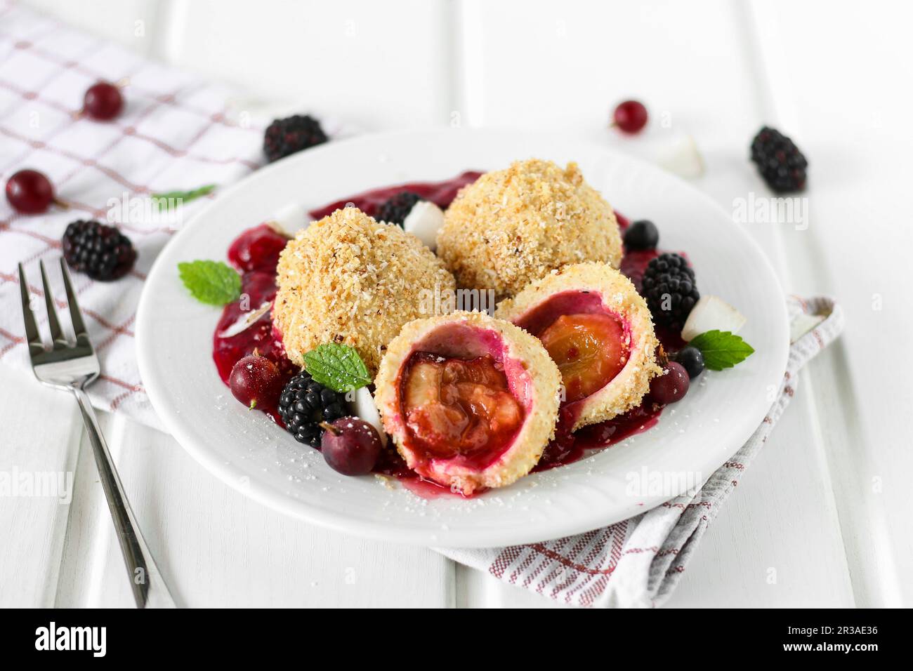 Damson dumplings in a pool of berry sauce Stock Photo - Alamy