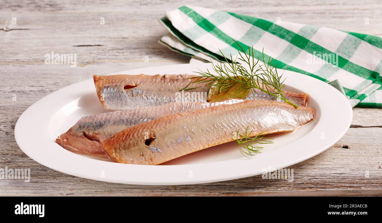 Smoked herring fillets with dill on an oval plate Stock Photo - Alamy