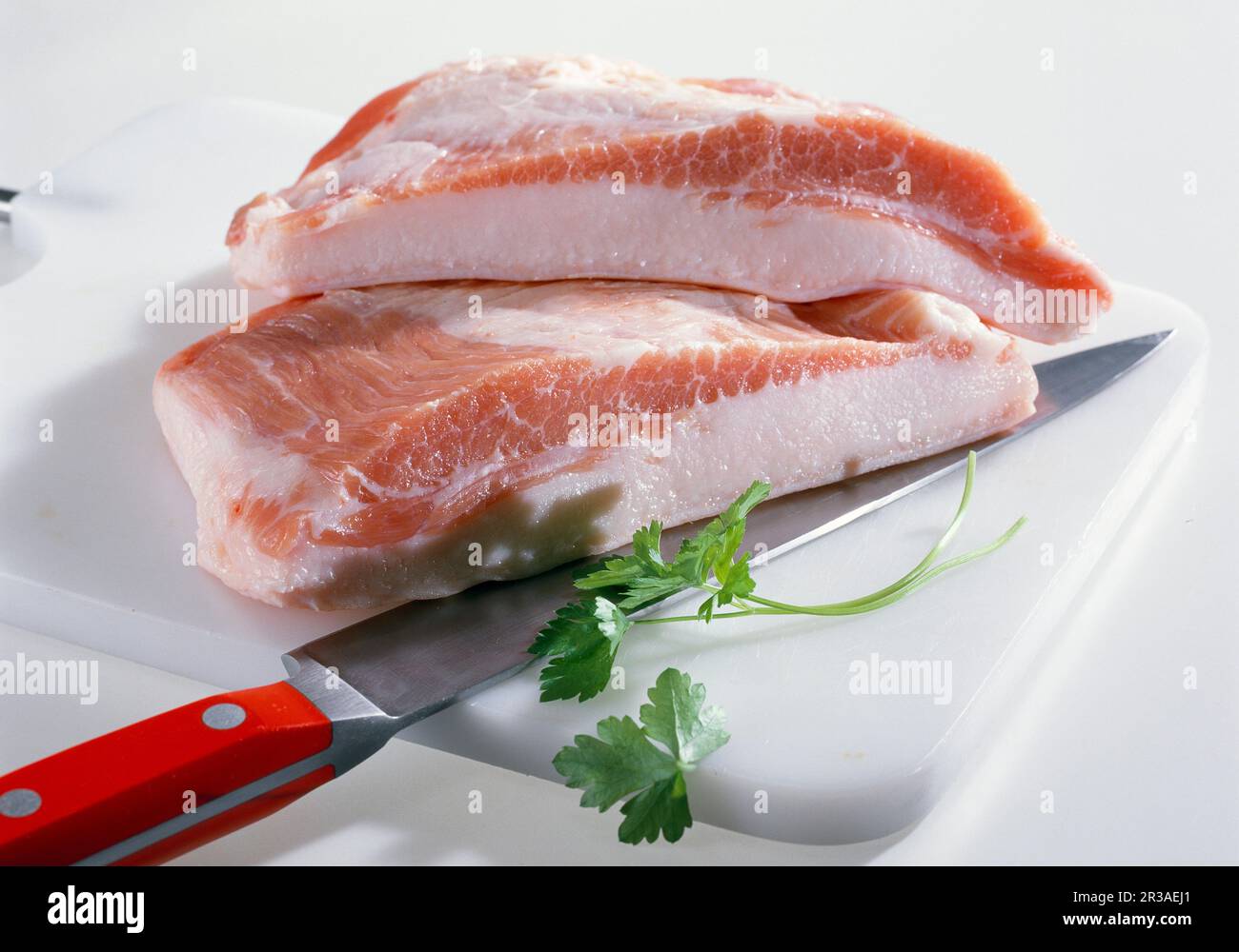 Raw pork cheeks with bacon on a cutting board with a knife Stock Photo ...