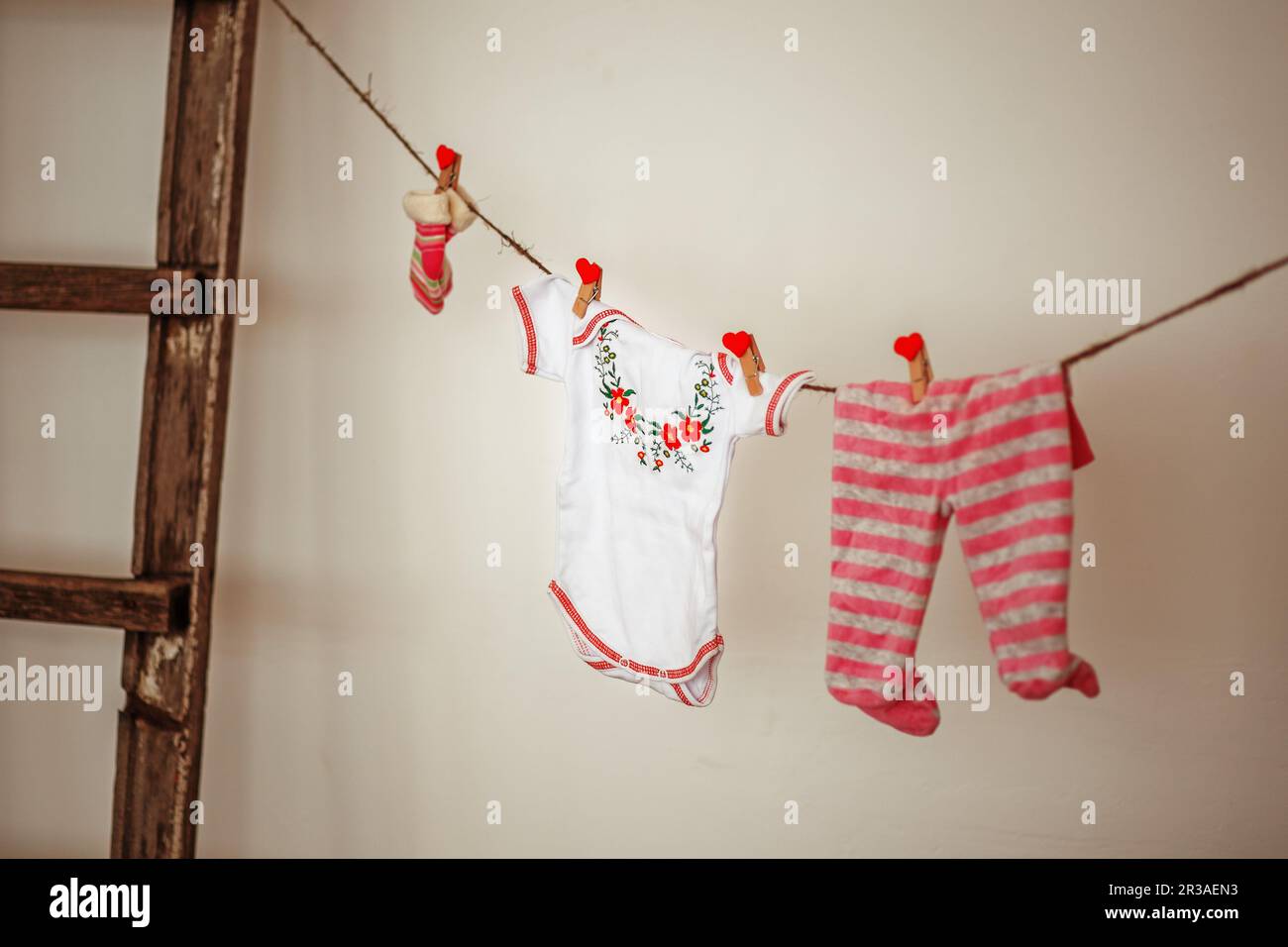 Things for the newborn girl hanging on rope Stock Photo - Alamy