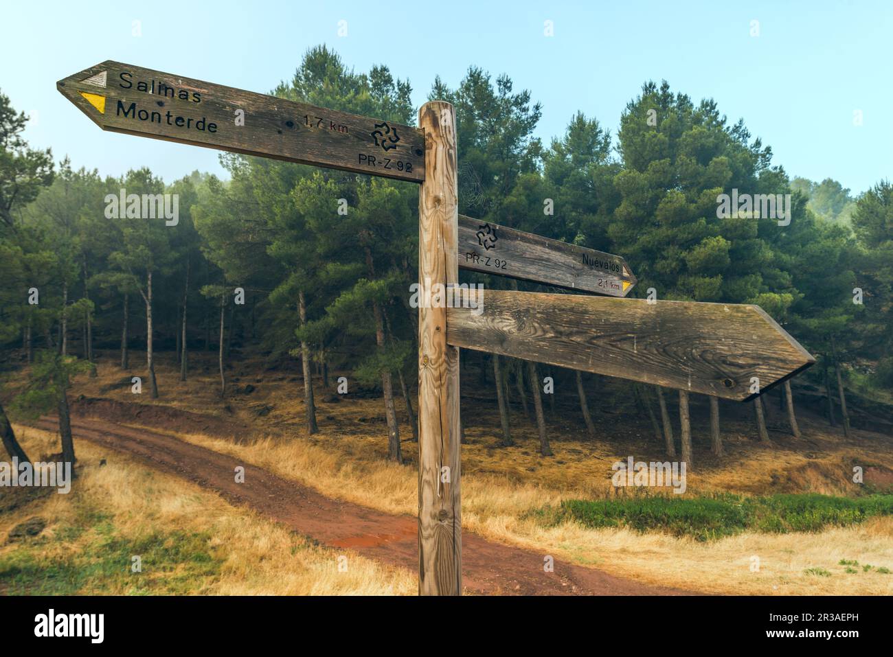 A wooden post with direction indicators on dirt roads for trekking in ...