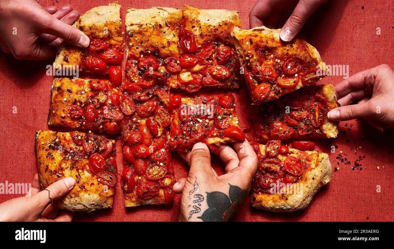 Roman style pizza topped with tomatoes and crushed red pepper flakes ...