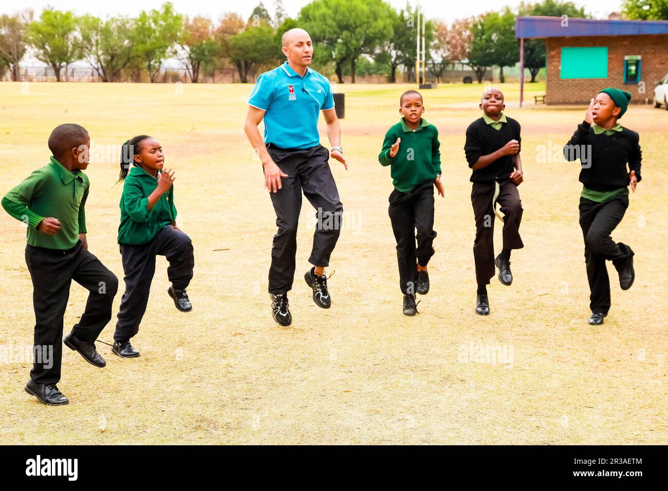 Diverse African Primary School children doing physical exercise PT ...