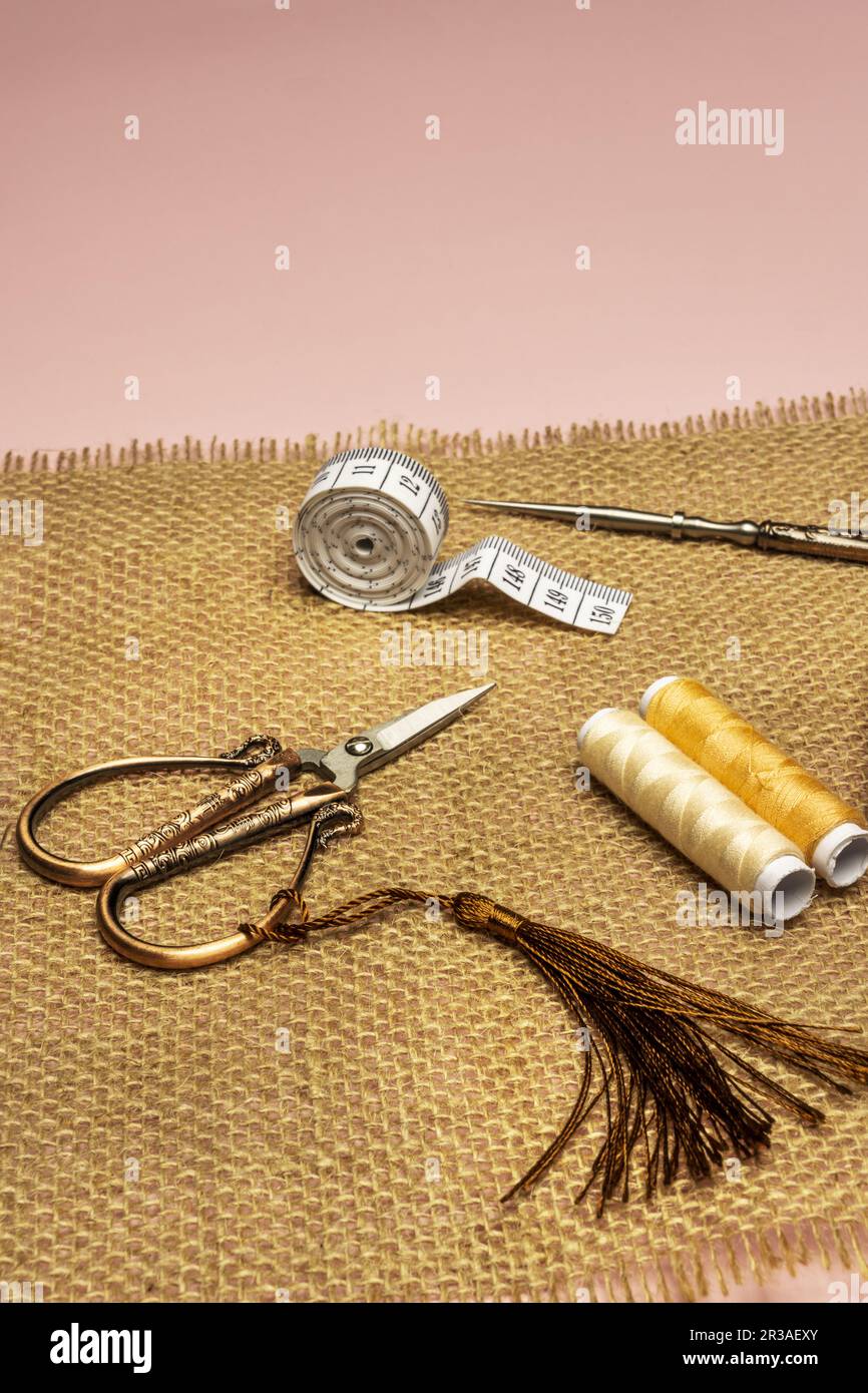 Sewing still life with vintage copper scissors next to a tape measure ...