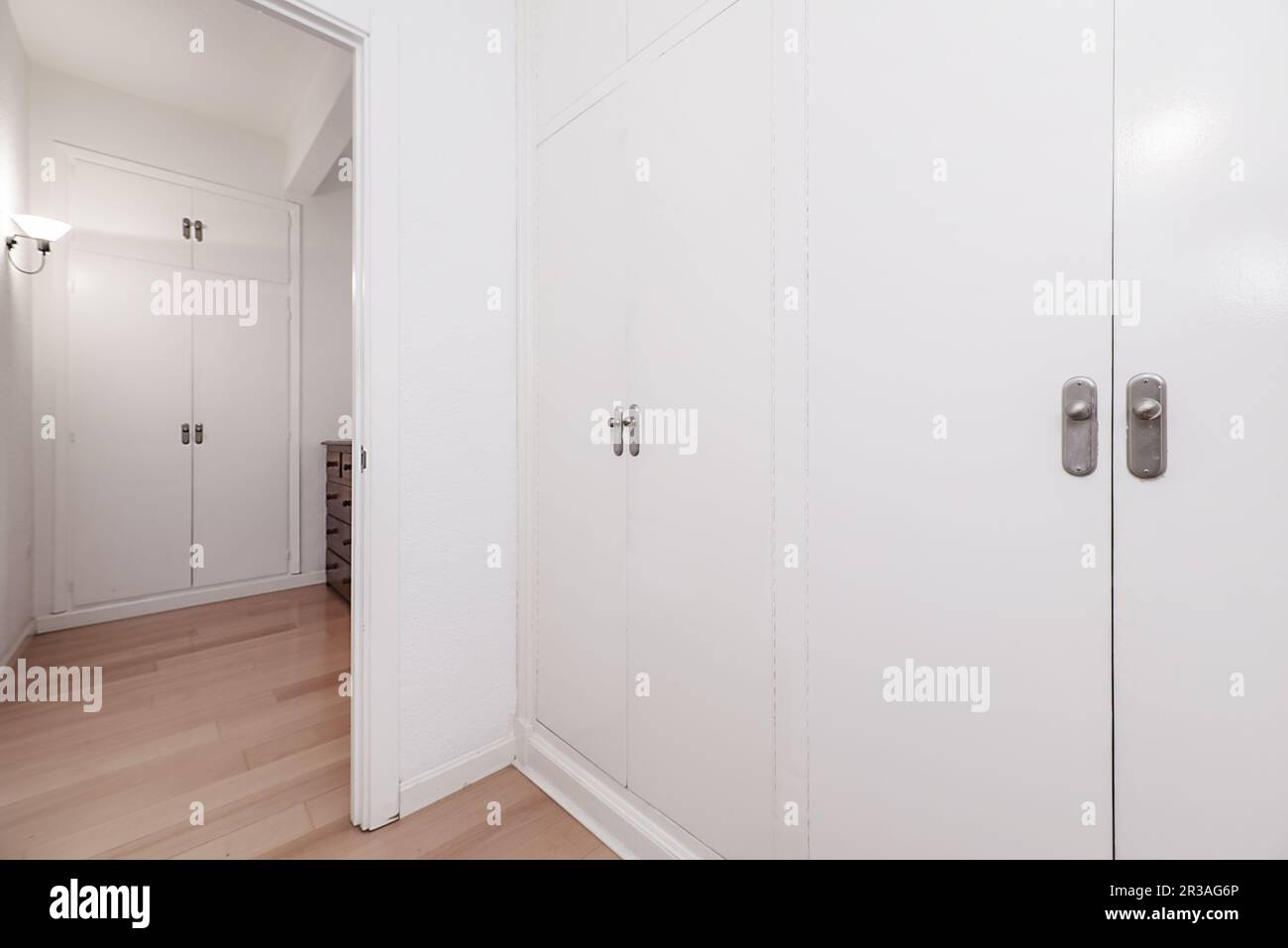 A dressing room with built-in wardrobes with white doors with gray ...