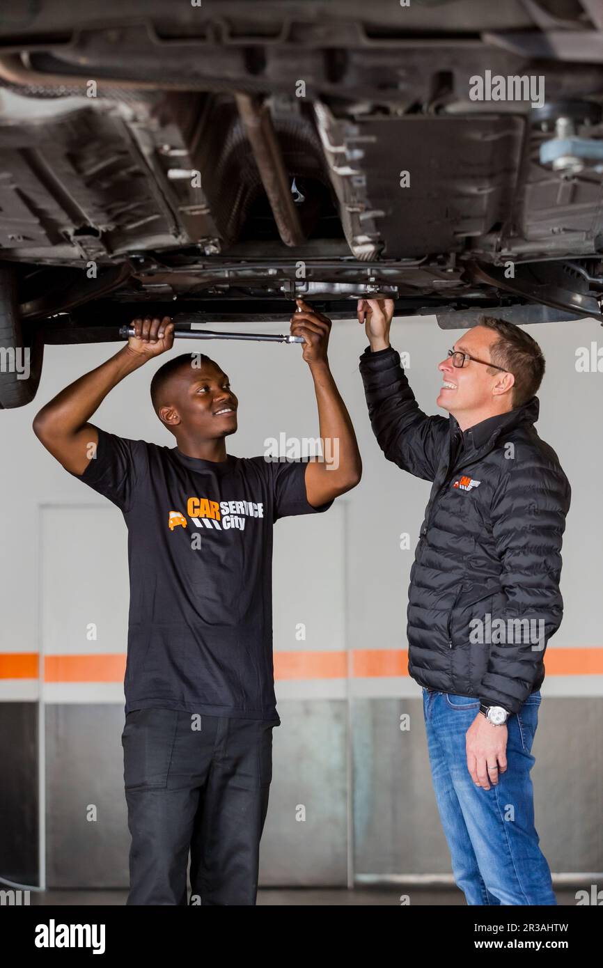 Mechanics in Car Service City Workshop repairing and diagnosing motor ...