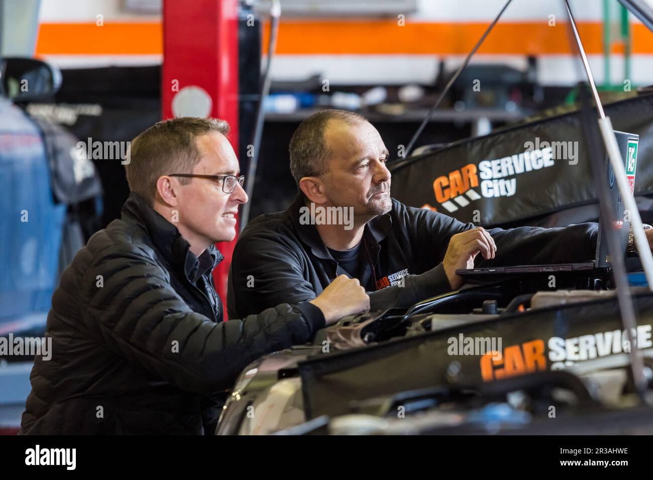 Mechanics in Car Service City Workshop repairing and diagnosing motor ...