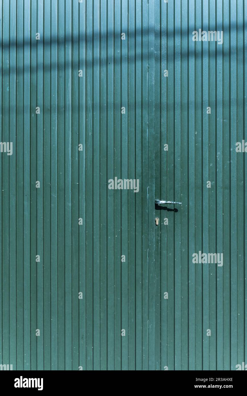 A green metal gate of a detached house with a handle and lock Stock ...
