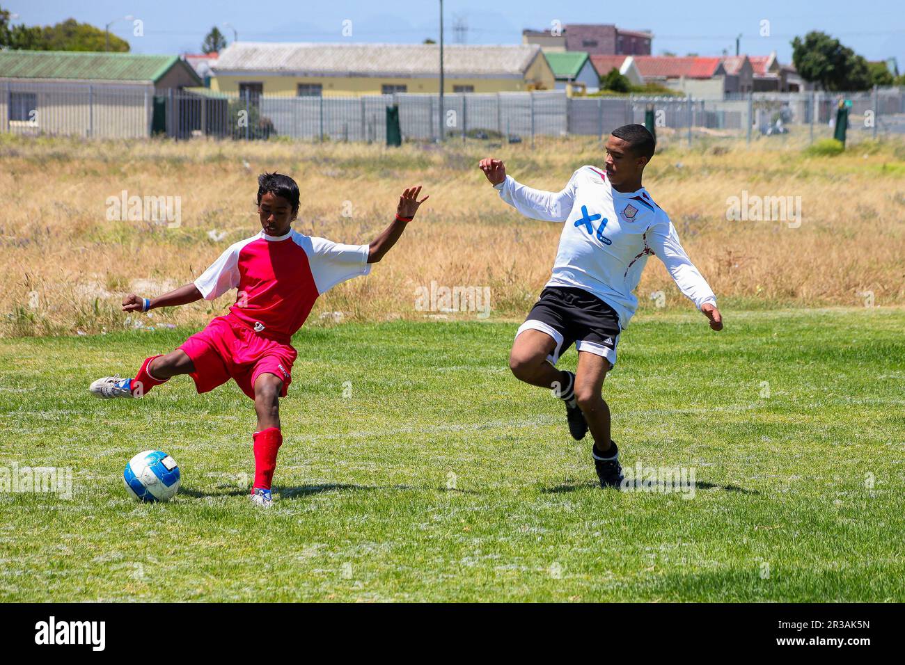 Diverse kids playing soccer at school hi-res stock photography and ...
