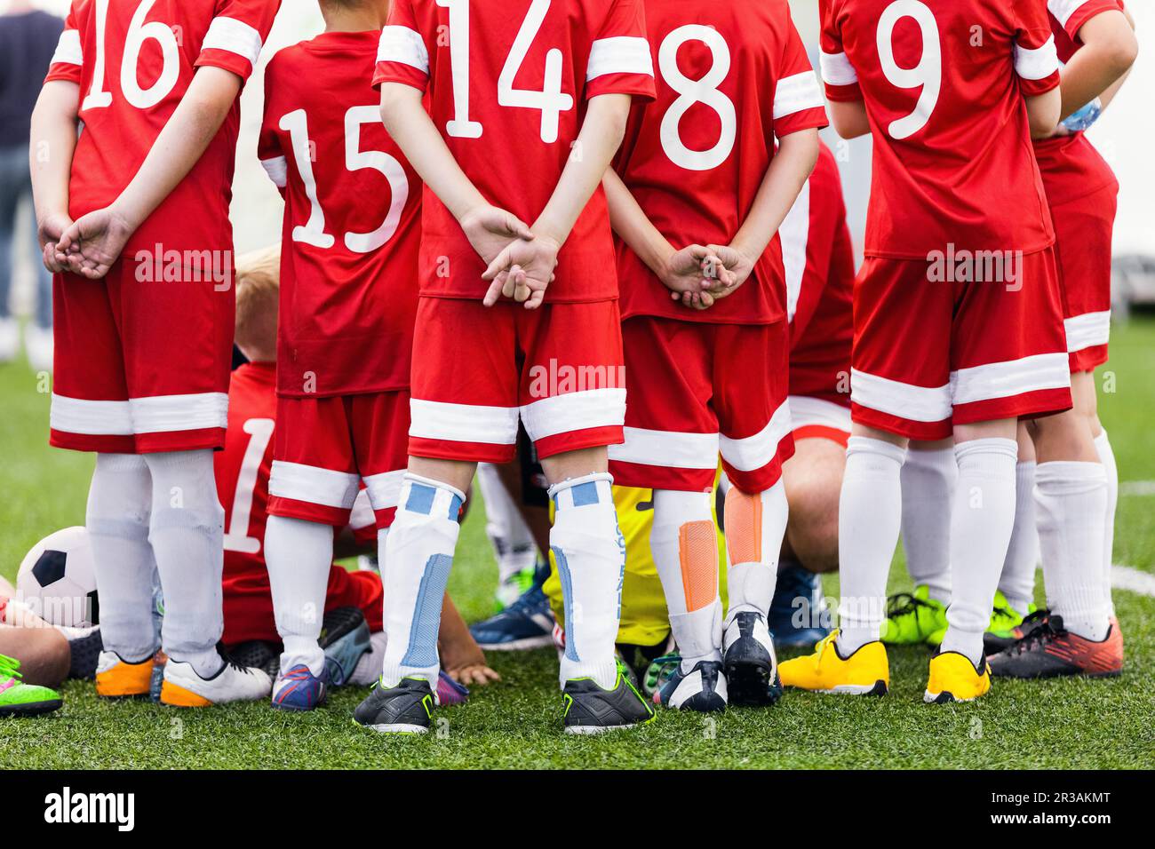 Coach giving young soccer team instructions. Youth soccer team standing ...