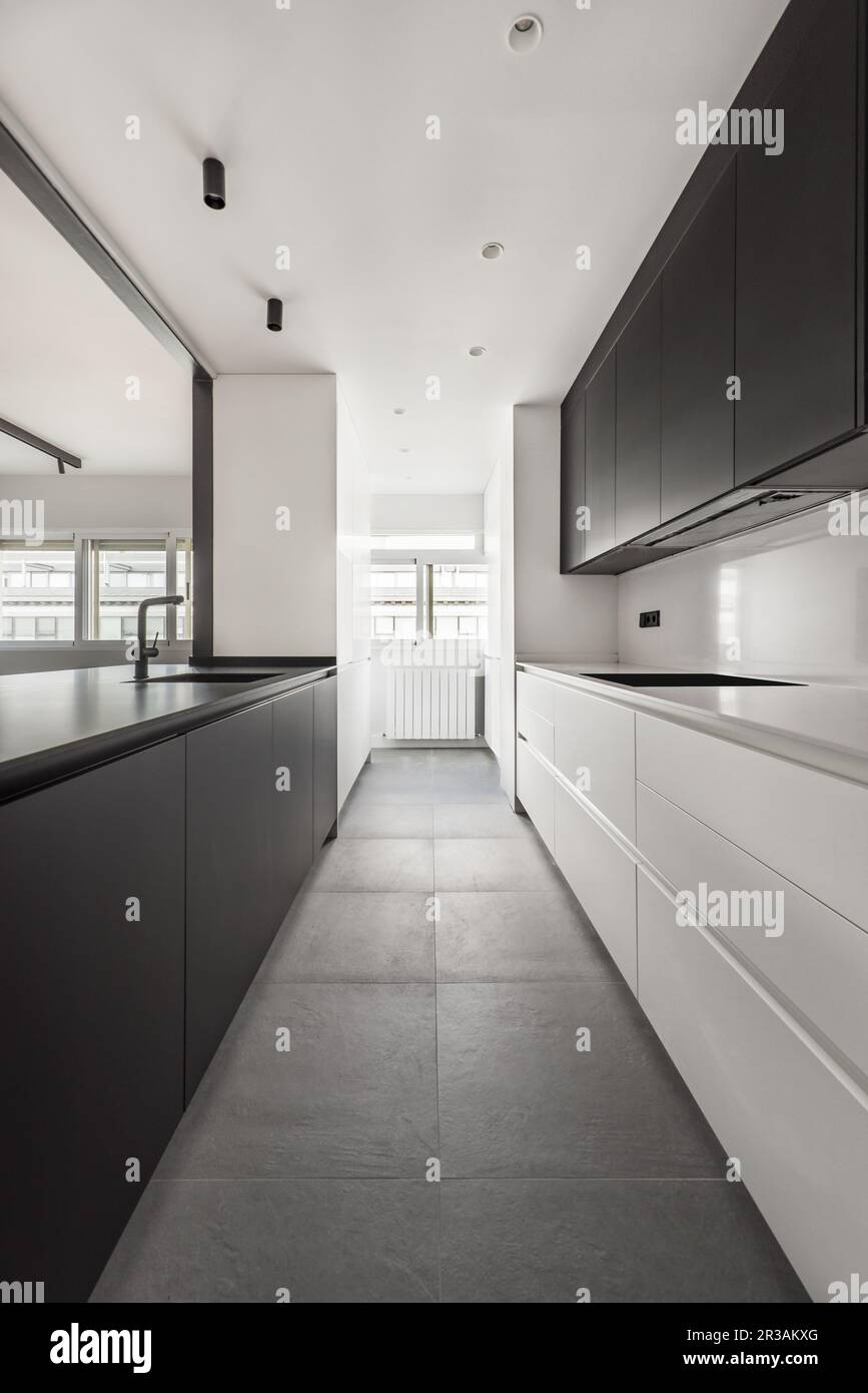 A narrow kitchen room fitted on both sides with a large serving hatch ...