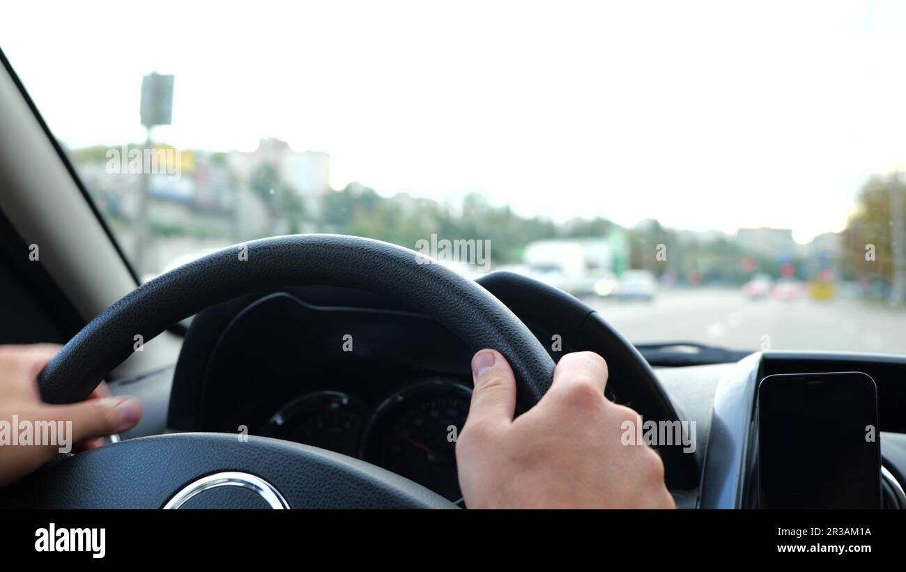 Close up of man hands on steering wheel. Slow motion. Male driving a ...