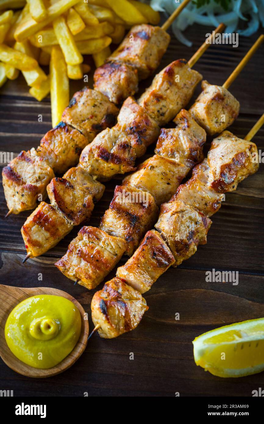 Greek souvlaki served with fried potatoes and mustard sauce Stock Photo ...