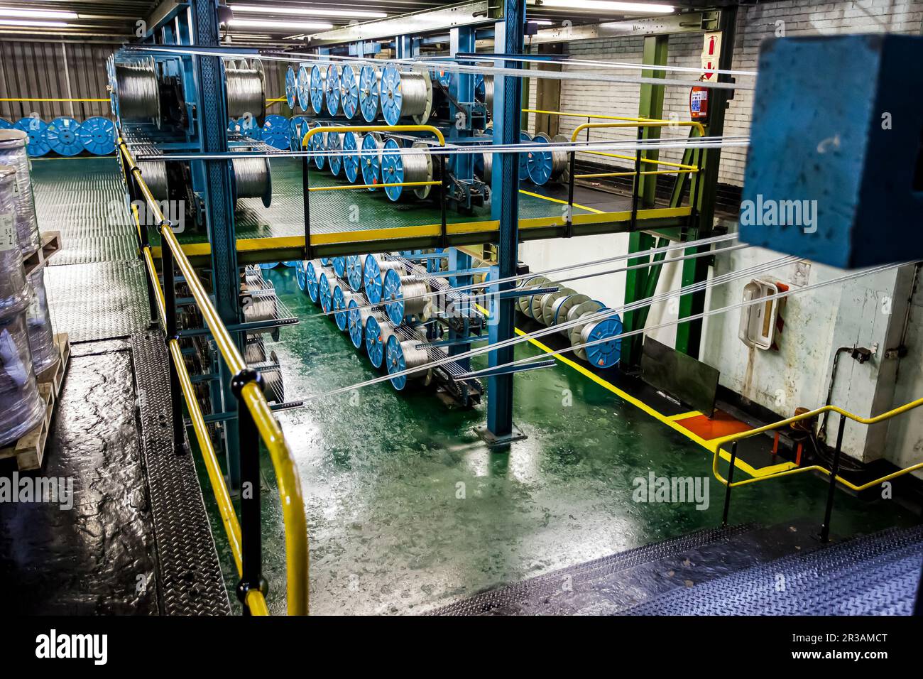Wide angle view of spools of cable on a large machine in a conveyor ...