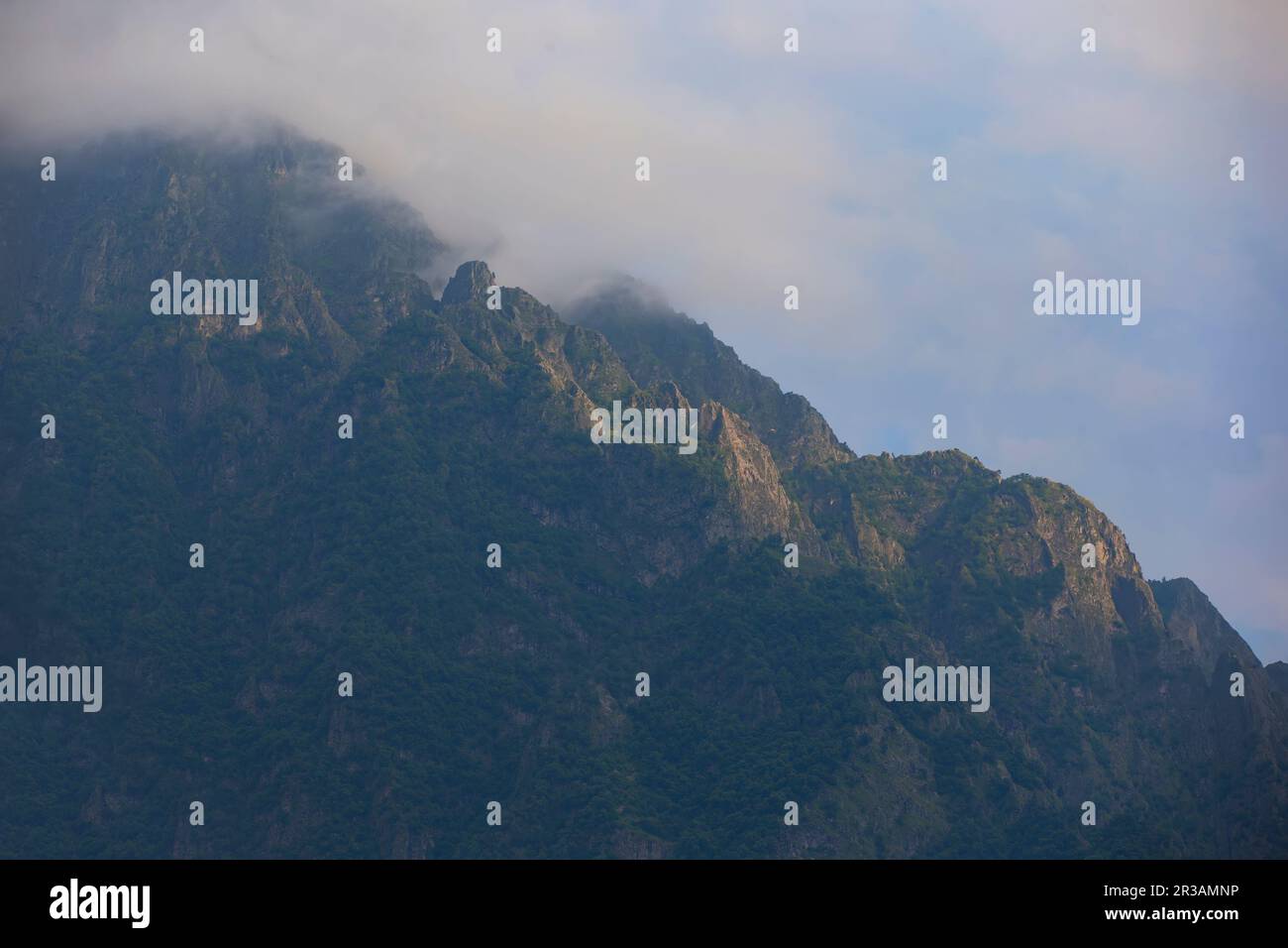 Dark atmospheric surreal landscape with a dark rocky mountain peak in ...