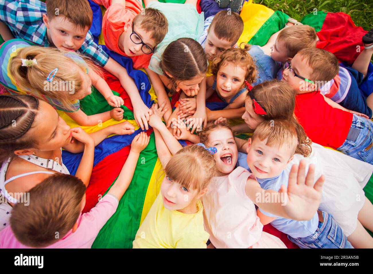 Children laying together in circle on colorful ground Stock Photo - Alamy