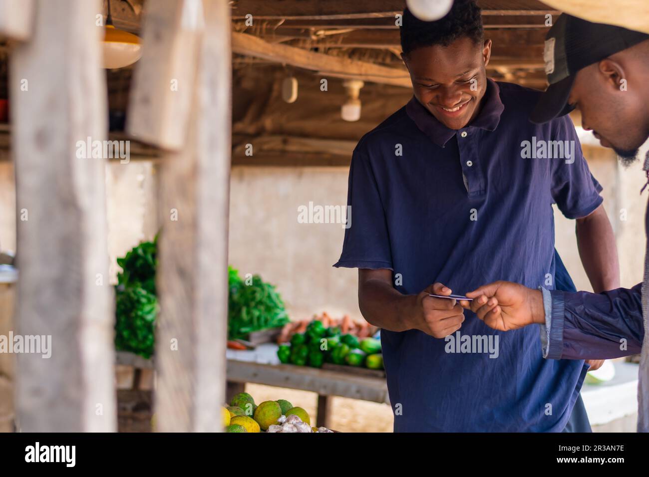 african man paying bills with credit card for goods bought in a african ...