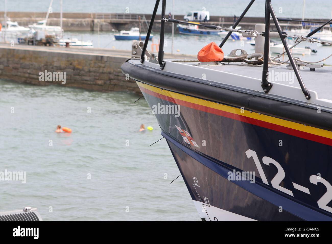 Swimmers pass the bow of RNLB Leonard Kent, Newcastle RNLI's lifeboat ...