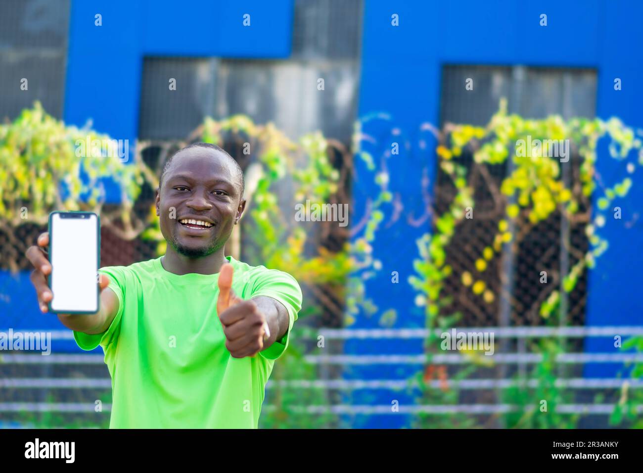 cheerful african adult smiles in delight looking at the camera holding ...