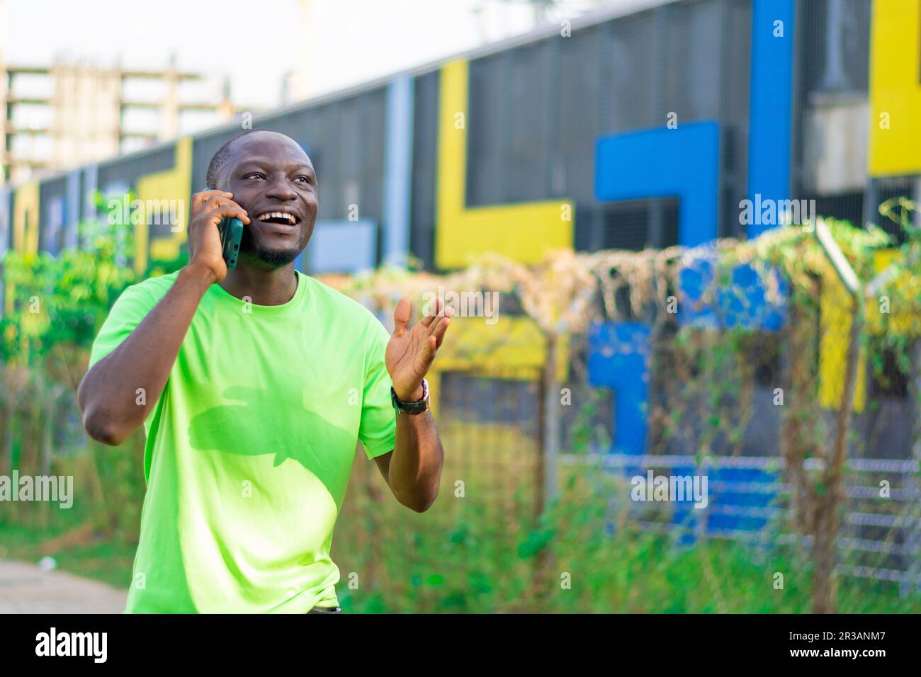 african man smiles joyfully using his mobile phone Stock Photo - Alamy