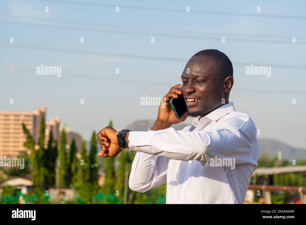 An Adult Man Stands Using A Mobile Phone A Portable Information Device