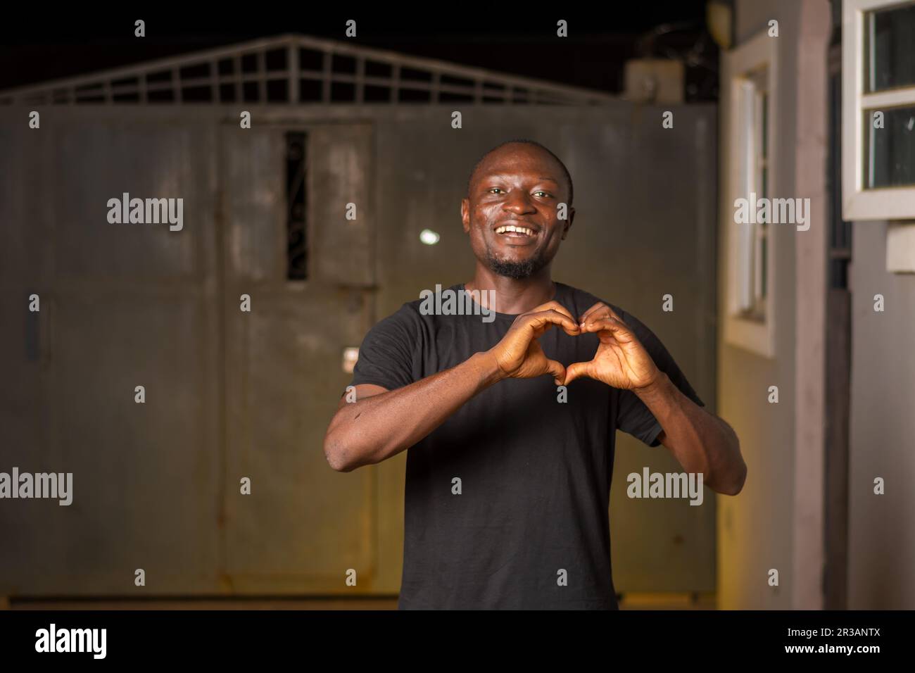 Good looking african man placing his both hands doing the heart symbol ...