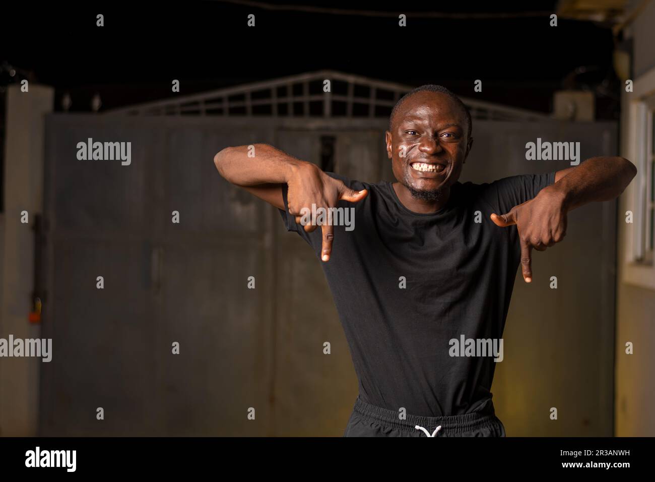 Excited young African man smiling pointing fingers aside at copy space ...