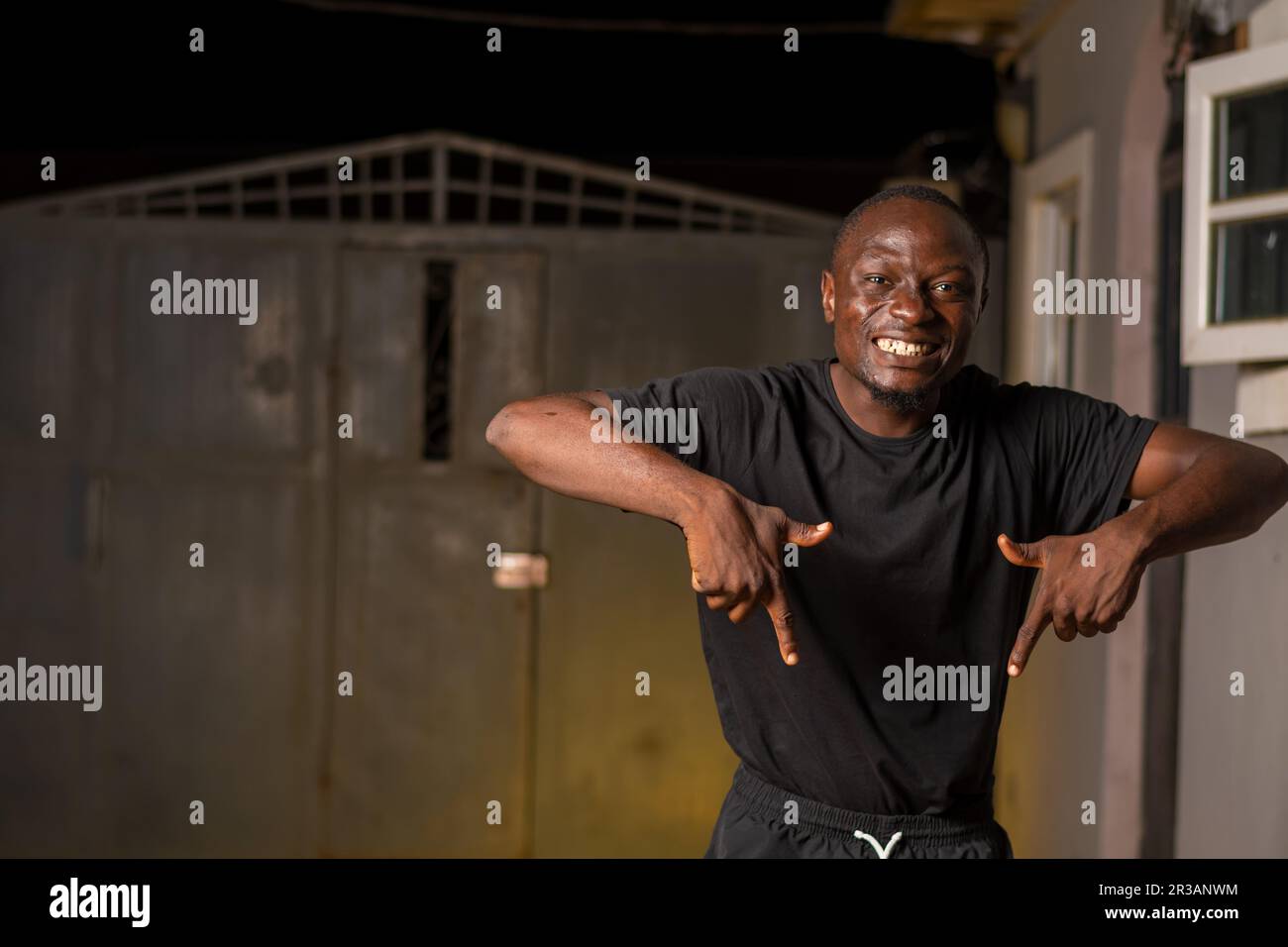 Excited young African man smiling pointing fingers aside at copy space ...