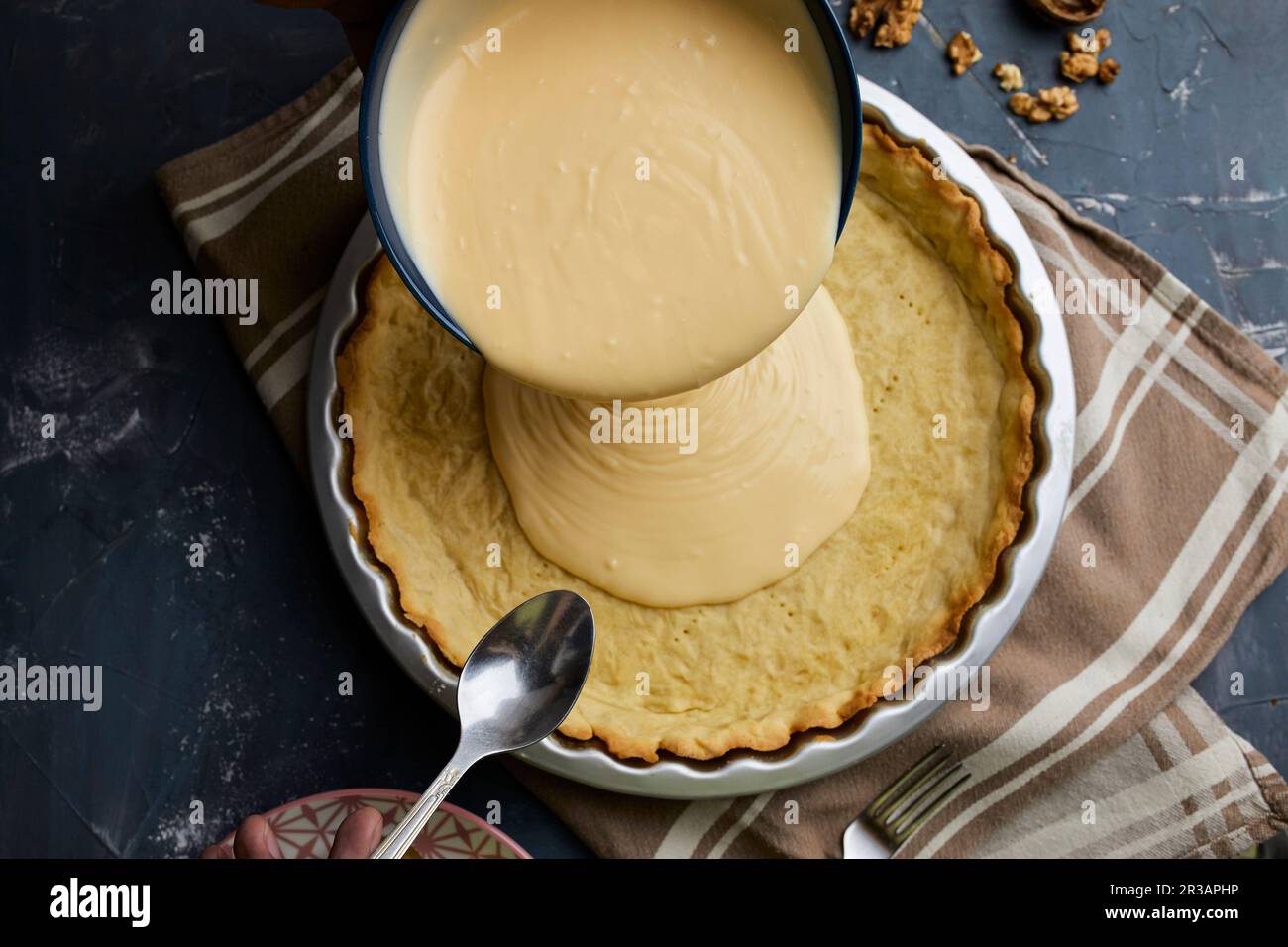 Pouring mascarpone filling in tart shell Stock Photo - Alamy