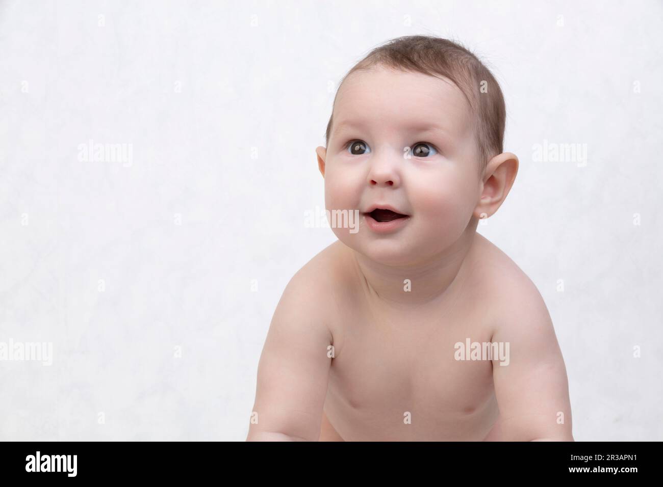 Six month old baby on a white background. Happy boy mid-range ...