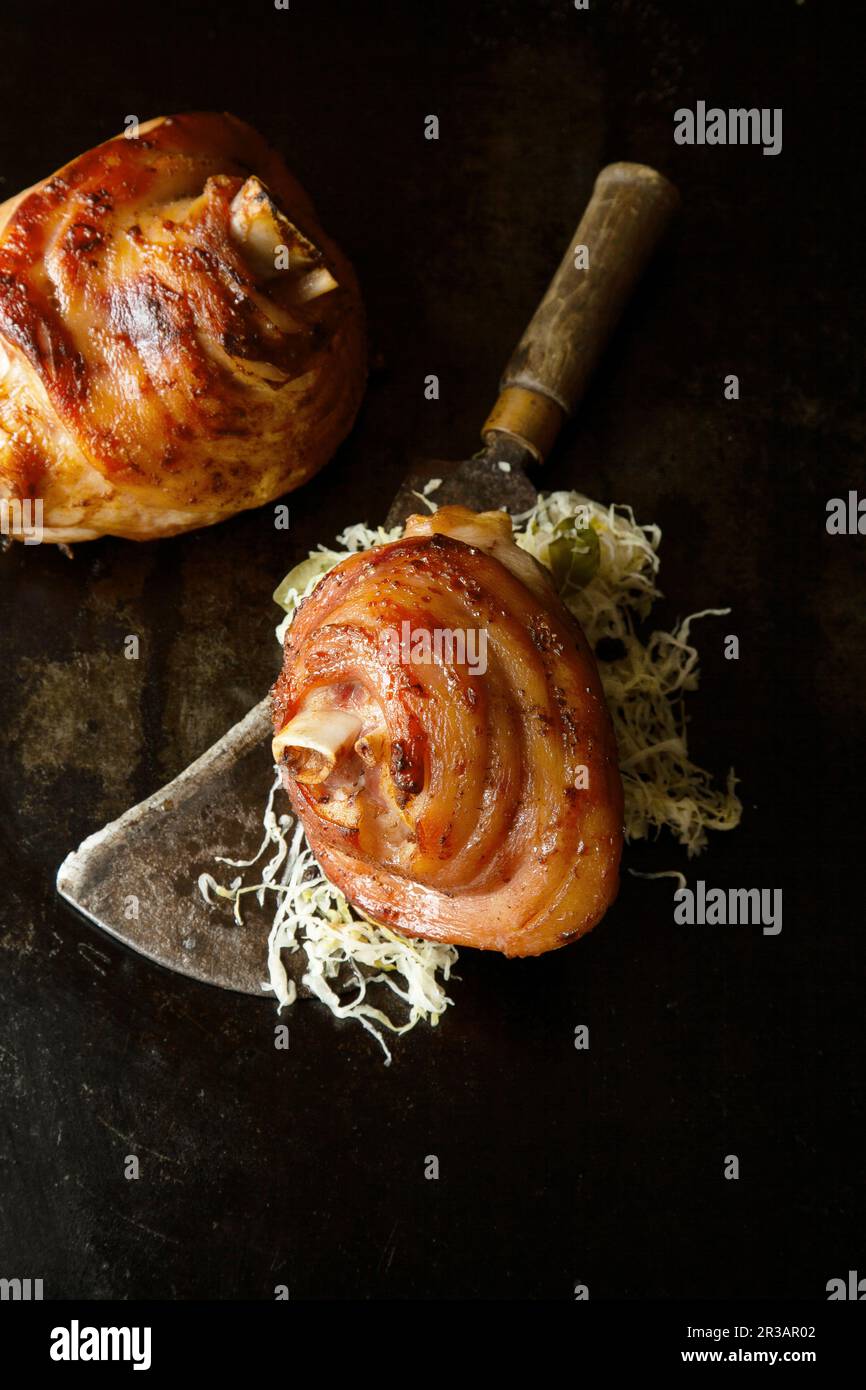 Grilled pork knuckles with sauerkraut on a meat cleaver Stock Photo - Alamy