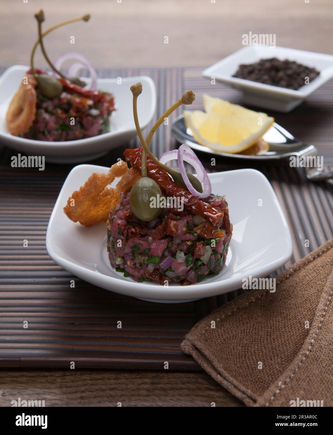 Tartare with capers, bread chips, onions and dried tomatoes Stock Photo ...