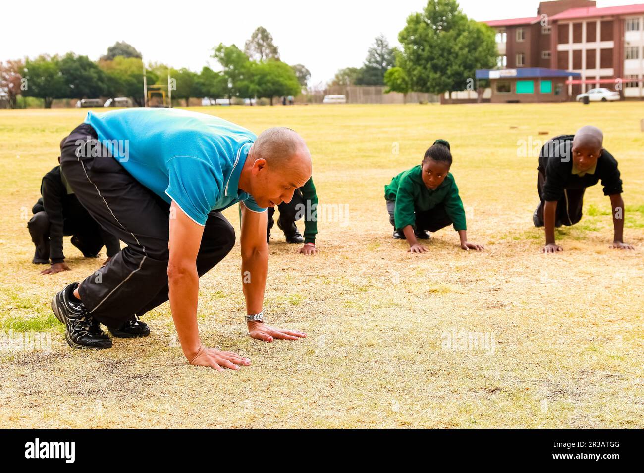 Diverse African Primary School children doing physical exercise PT ...