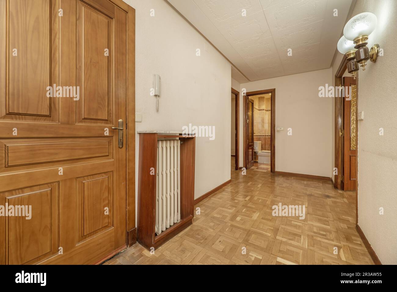 Entrance hall of a residential house with oak floors, wooden radiator ...