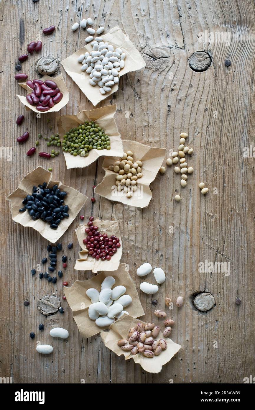 Different types of beans on a rustic wooden table Stock Photo - Alamy