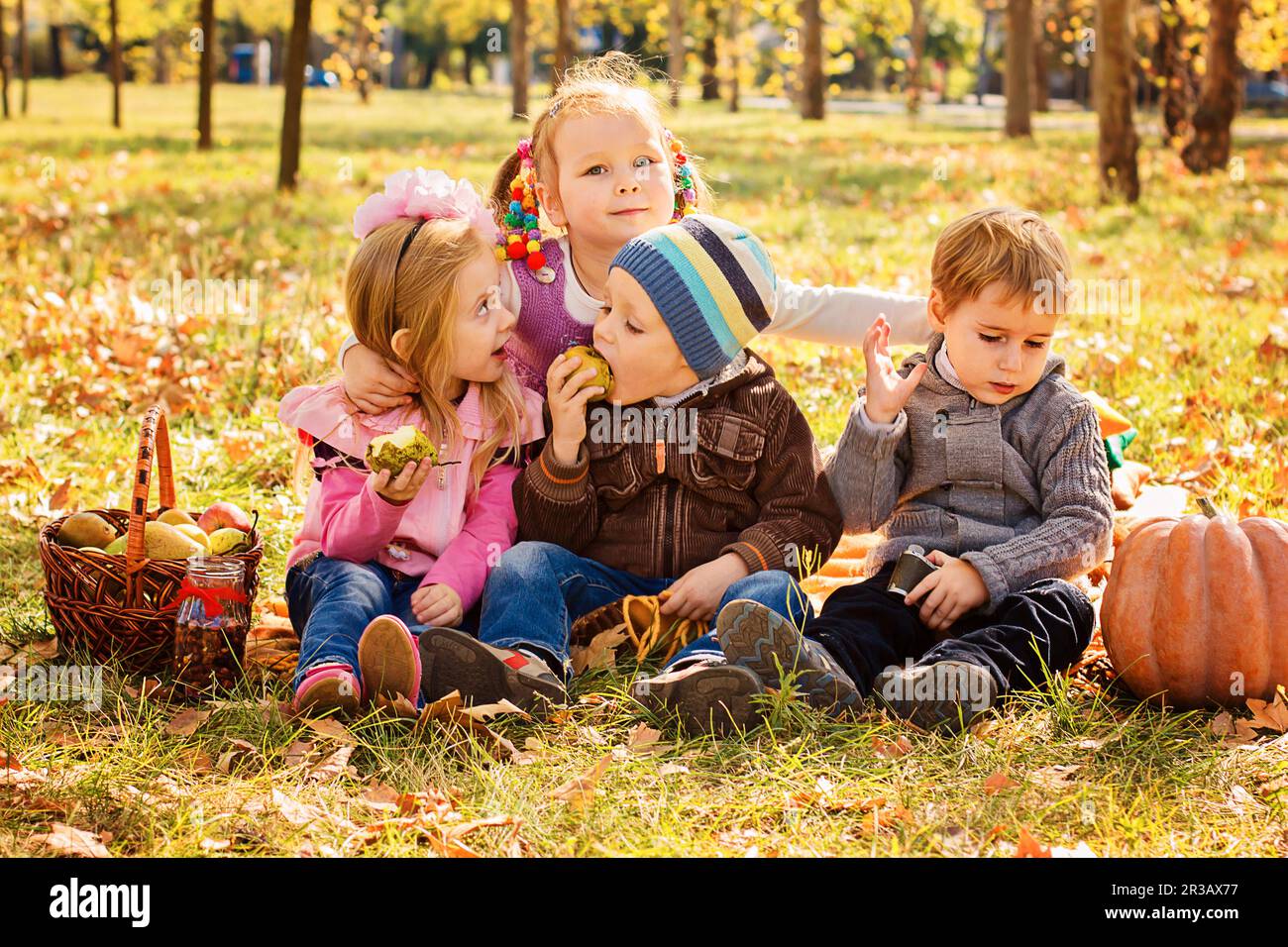 Four happy children playing in autumn park Stock Photo - Alamy