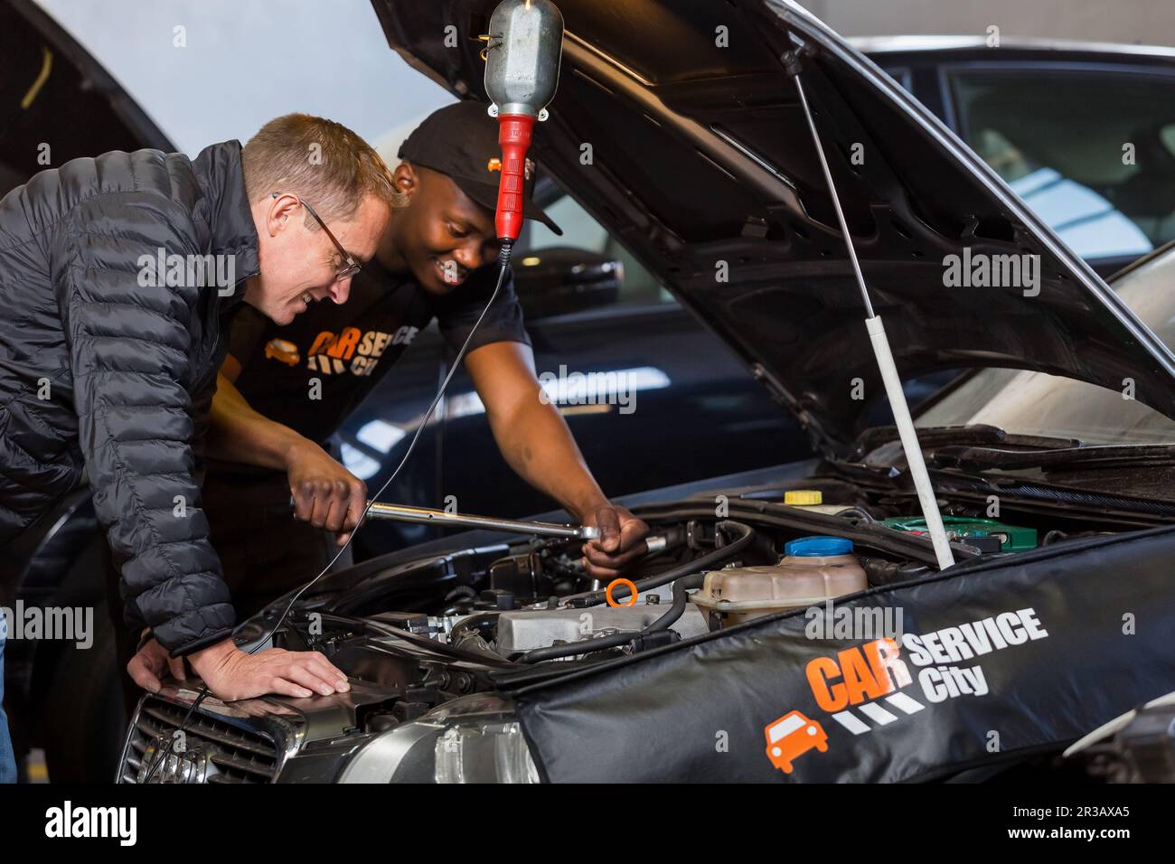 Mechanics in Car Service City Workshop repairing and diagnosing motor ...