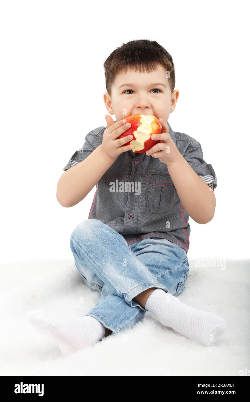 Little boy eating a red apple isolated on white background Stock Photo ...