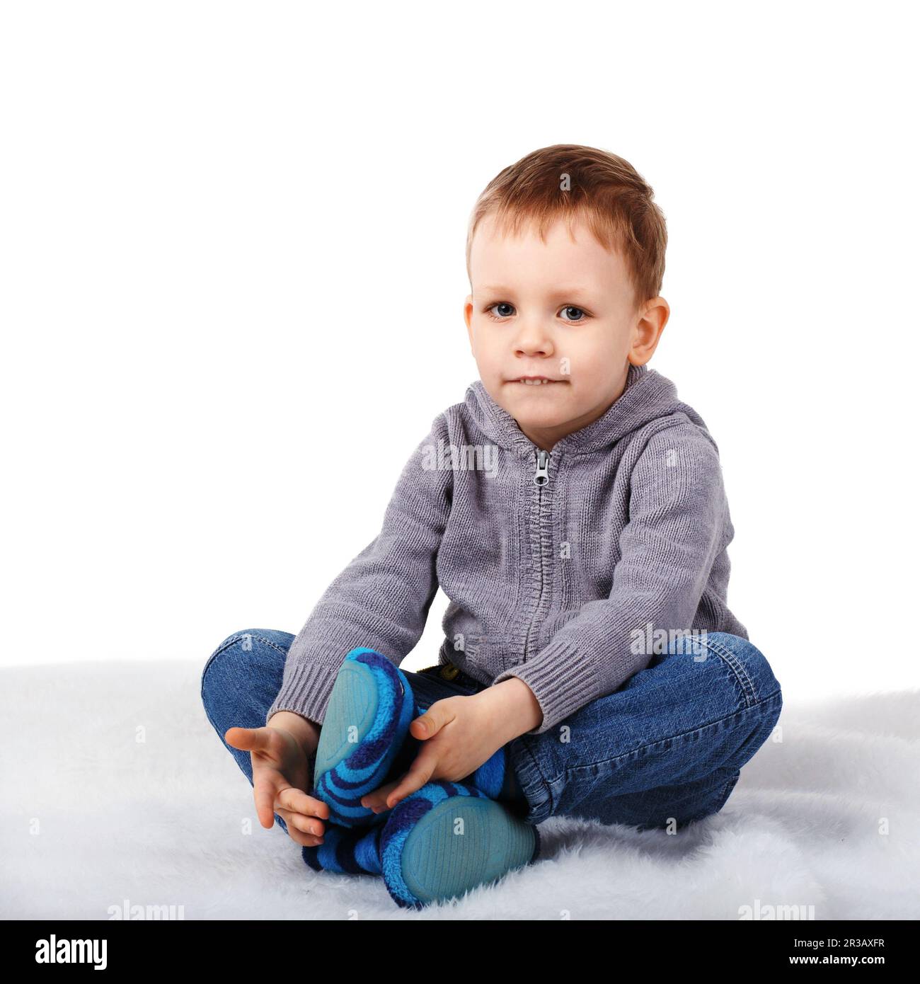 Little cute boy sitting on the floor biting her lower lip isolated on ...