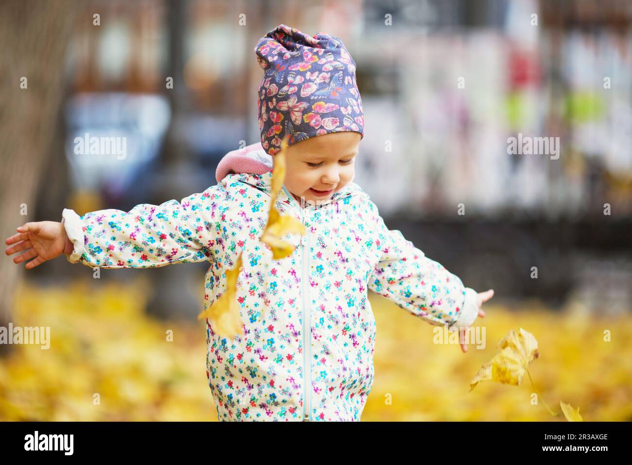Happy urban little girl walking in city autumn park. Cute baby girl ...
