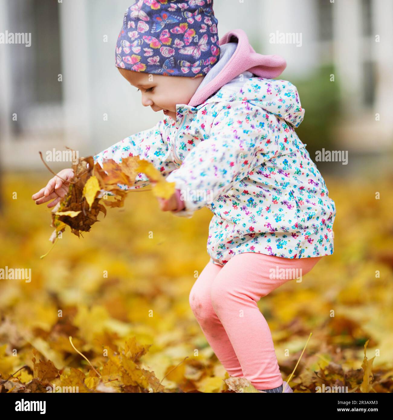 Happy urban little girl walking in city autumn park. Cute baby girl ...