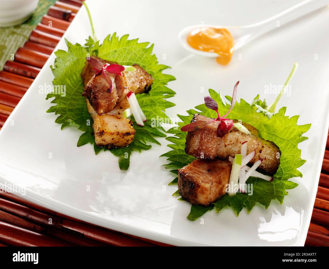 Roast pork belly with slivers of red radish and green apple served on ...