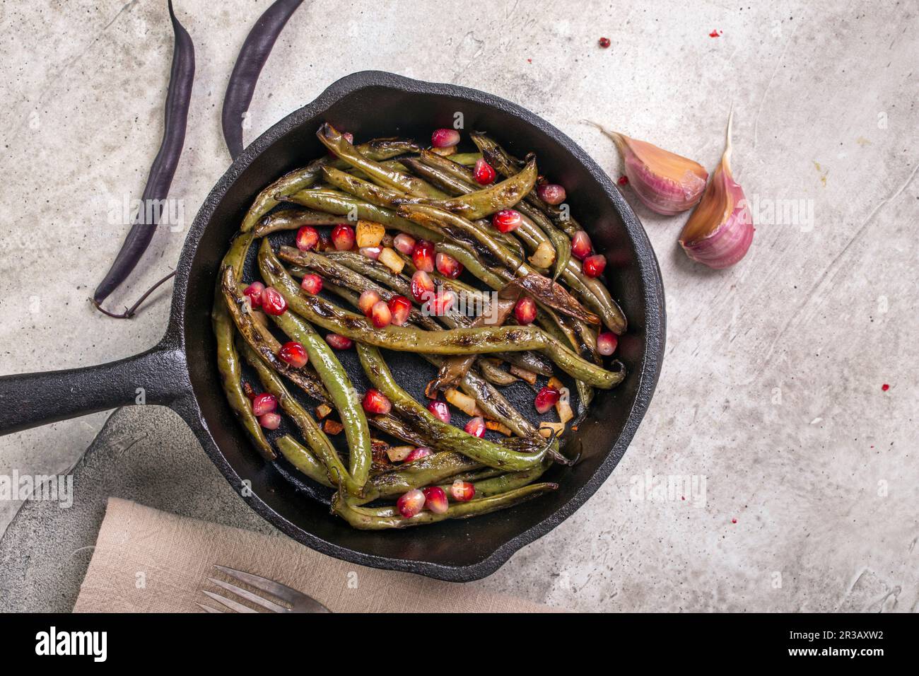 Charred green beans with garlic and pomegranate seeds Stock Photo - Alamy