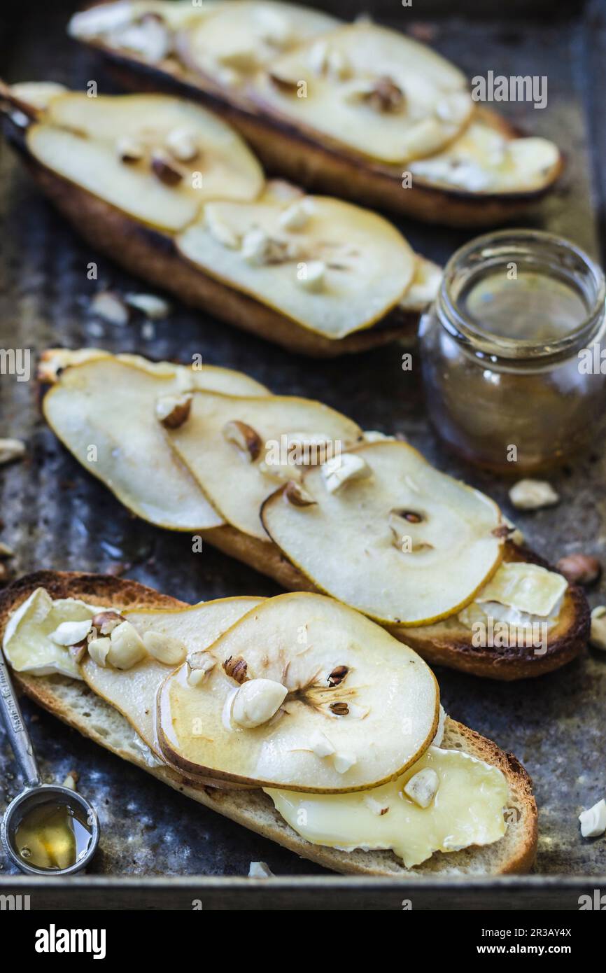 Toasts with camembert cheese, pears, walnuts and honey Stock Photo - Alamy