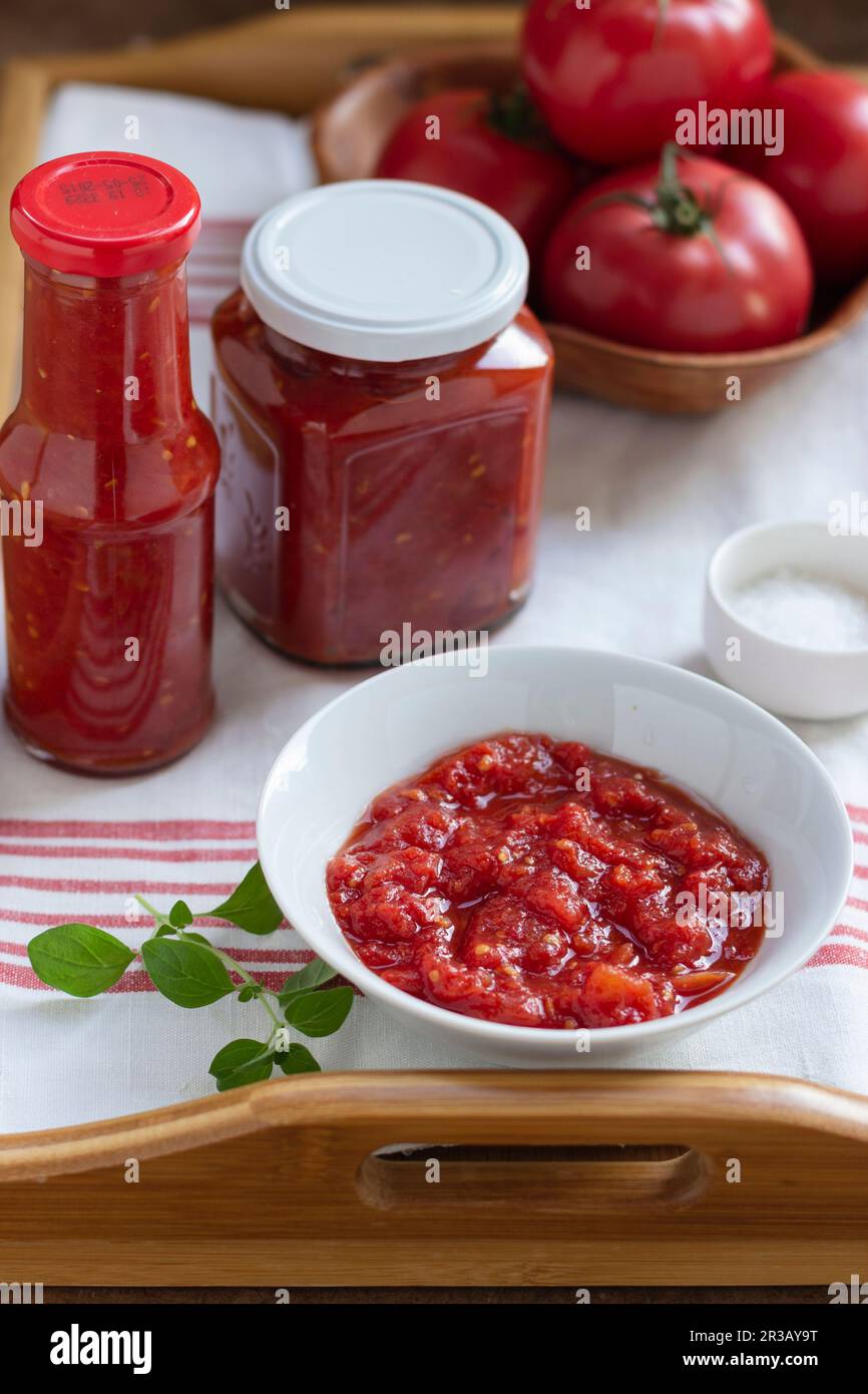 Homemade tomato puree in a ball and in jars, fresh tomatoes Stock Photo ...