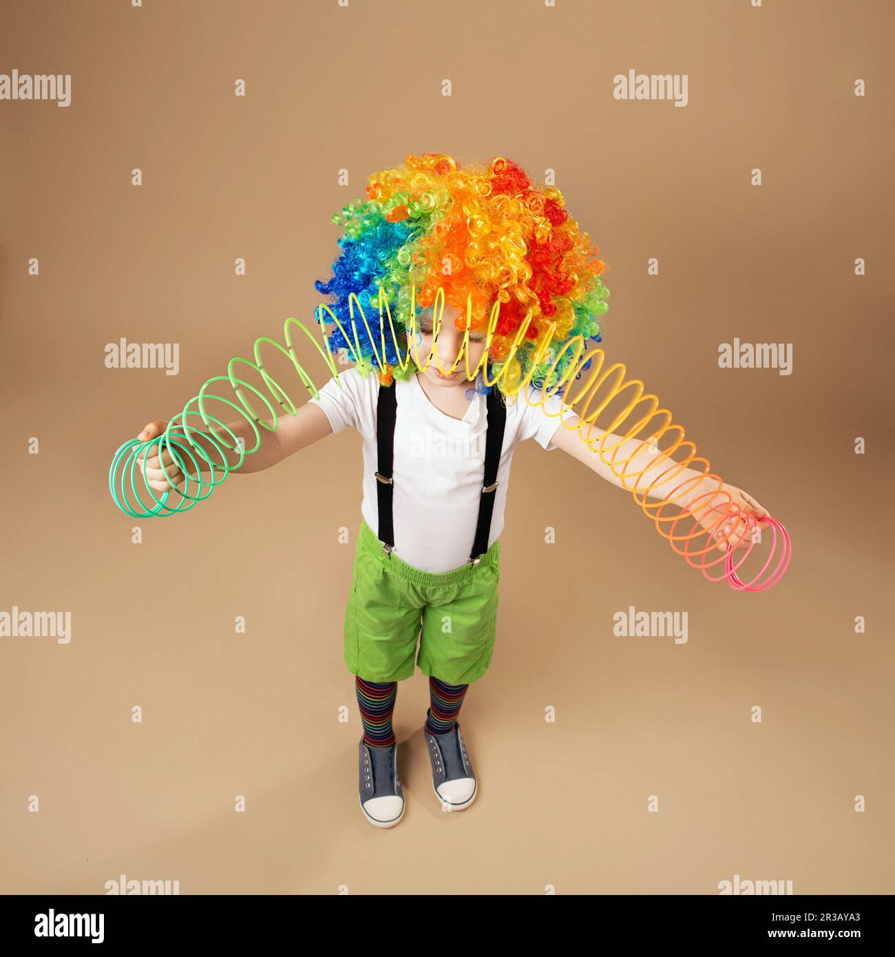 Happy clown boy with large colorful wig. Little boy in clown wig ...