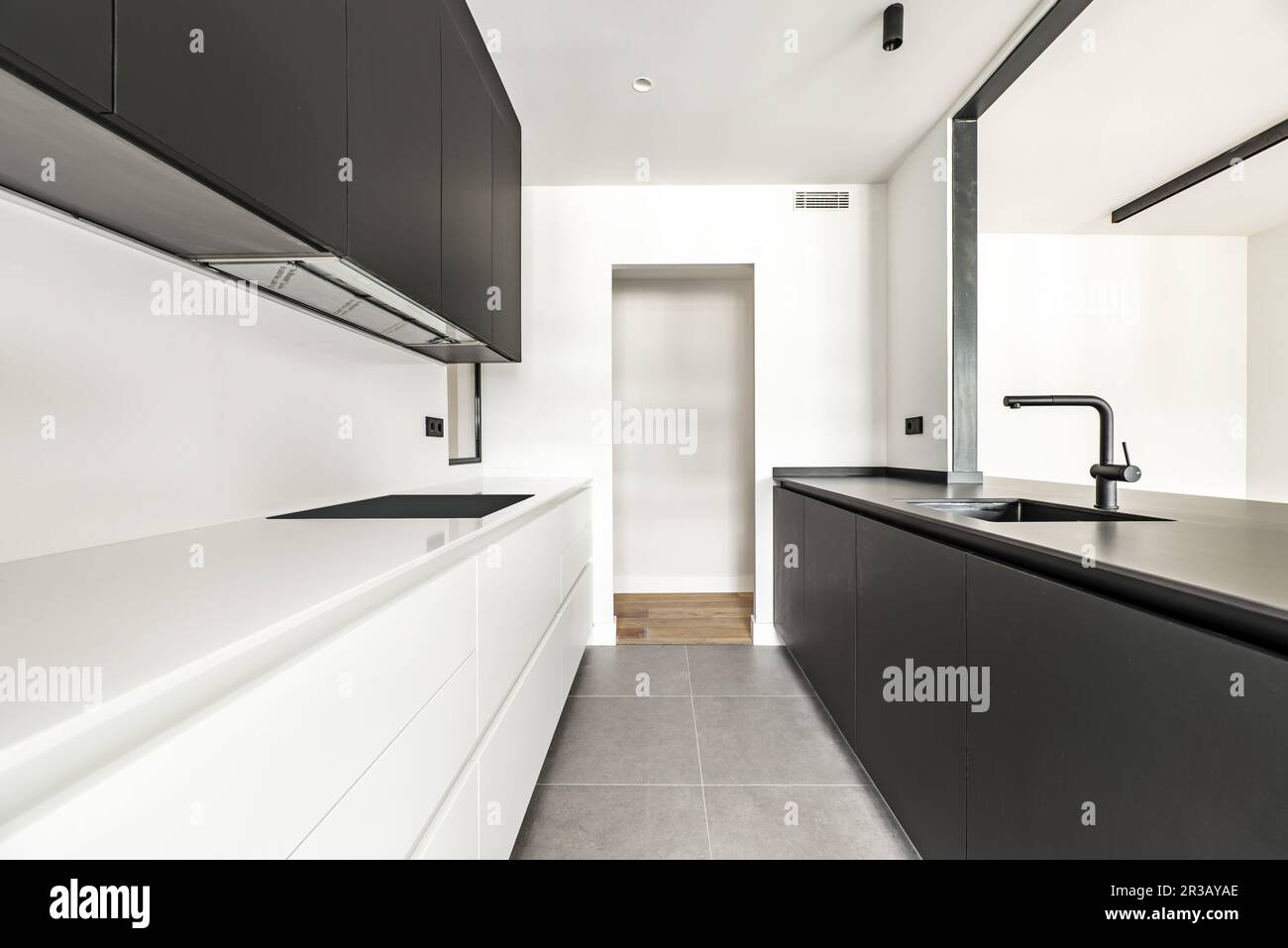 Kitchen furnished with a combination of black and white furniture ...