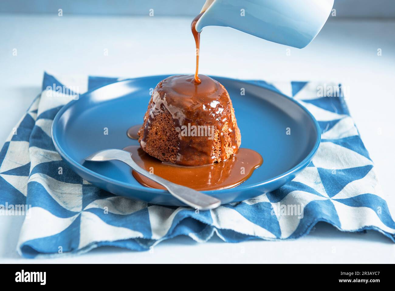 Hot toffee pudding with toffee sauce poured Stock Photo - Alamy